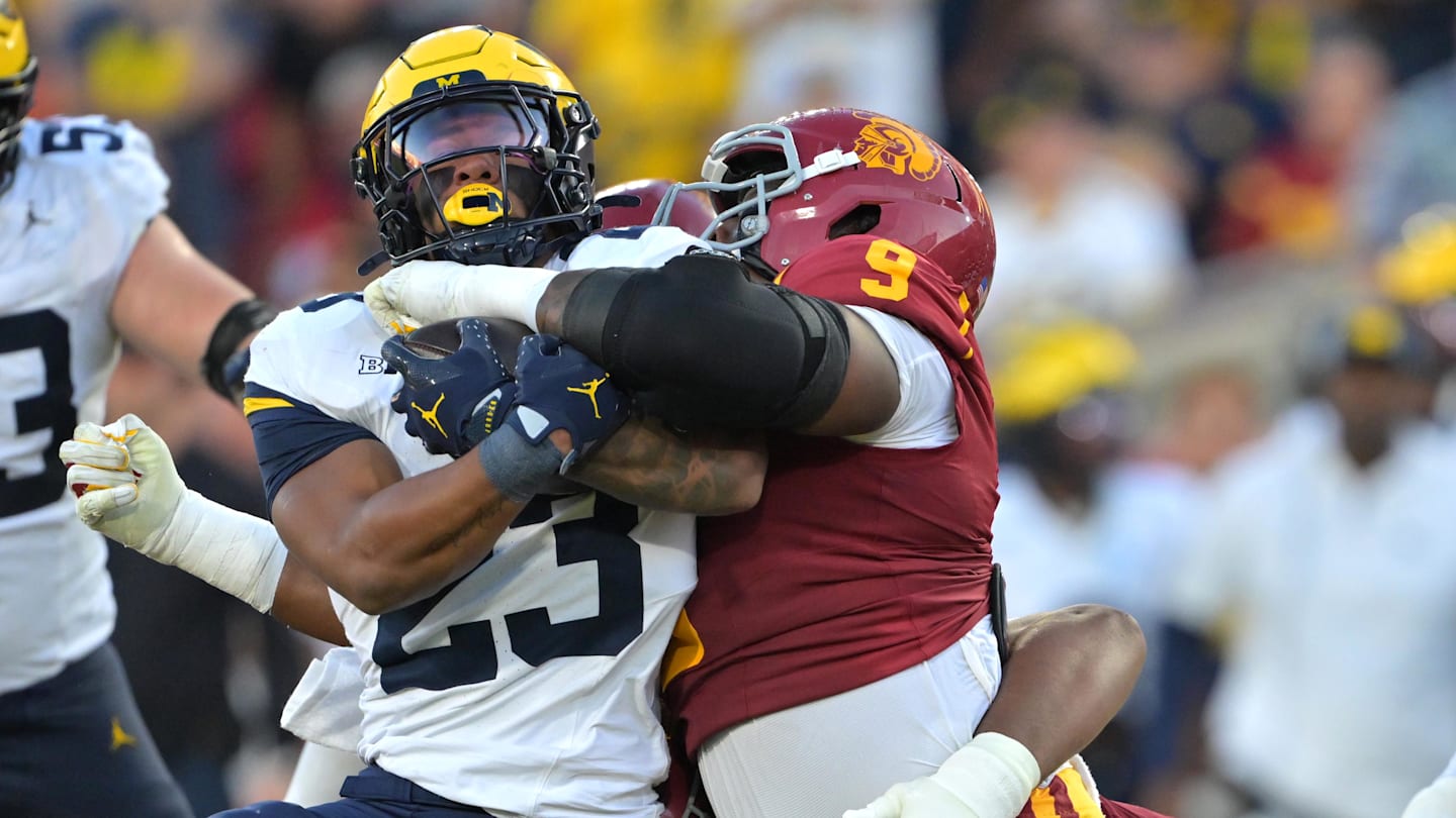 Handing out game balls in the Washington vs. Michigan game