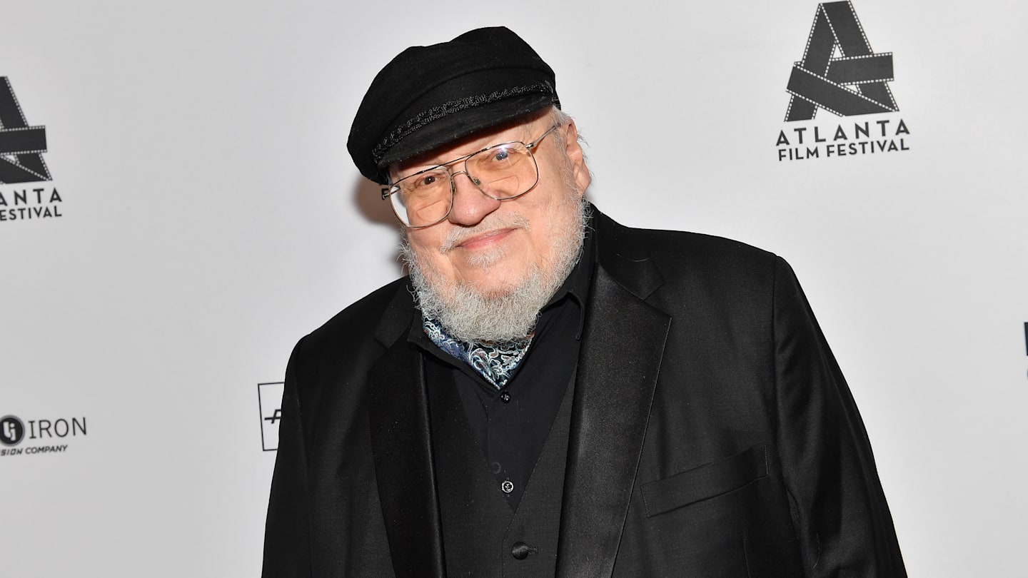 George R.R. Martin holds the first dire wolf born in 10,000 years